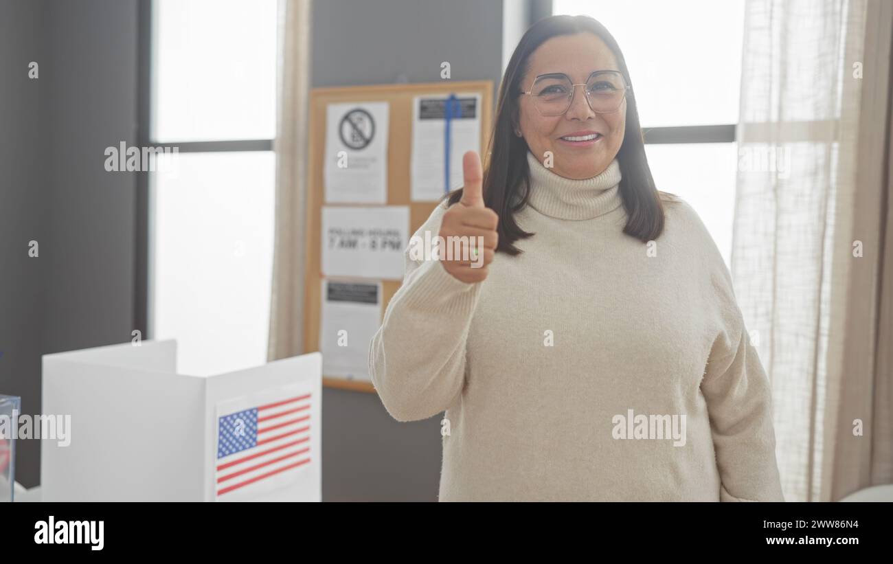 Smiling hispanic woman giving thumbs up in a usa voting center with ...