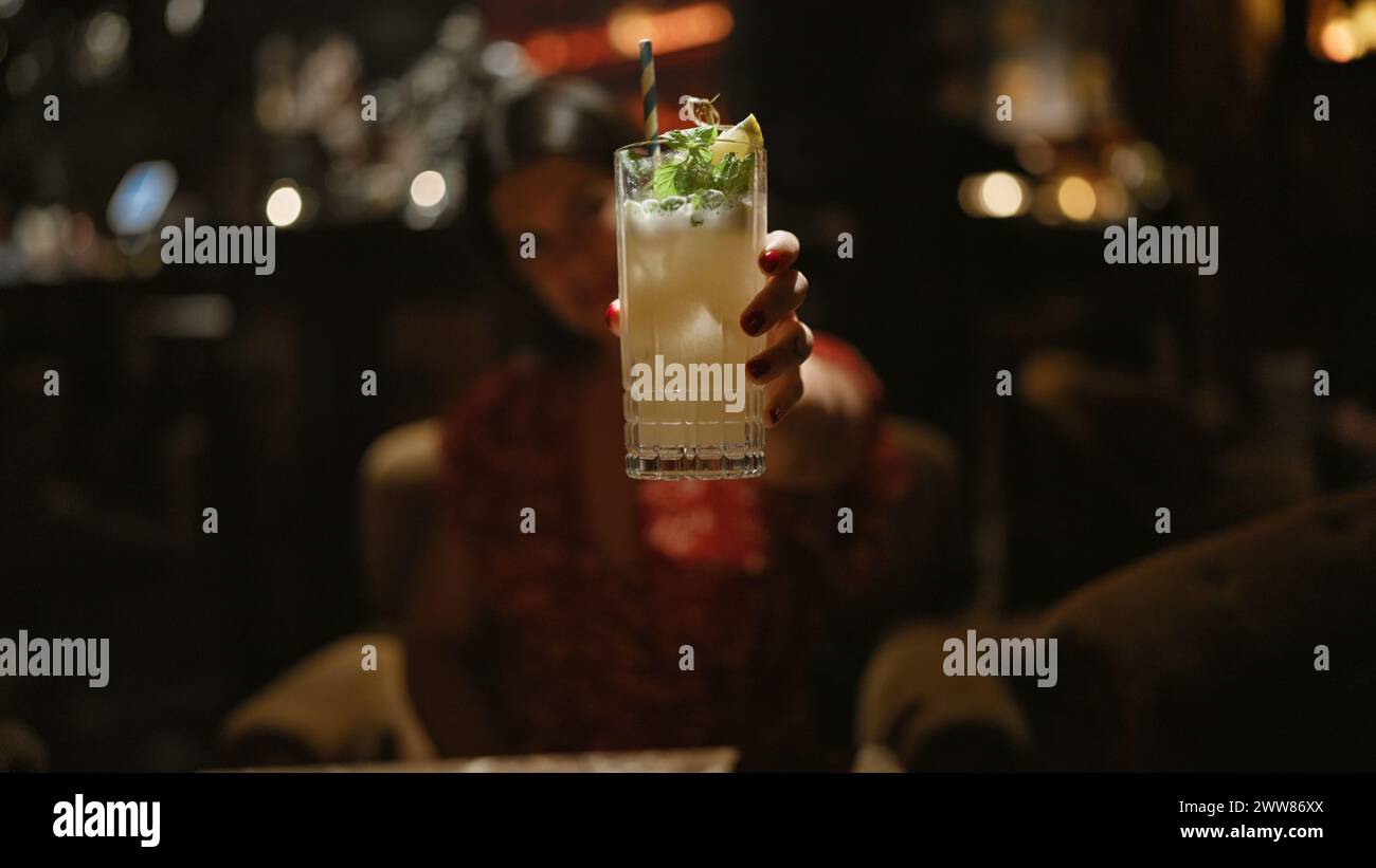 Cheerful, beautiful hispanic woman enjoying a tropical cocktail drink ...