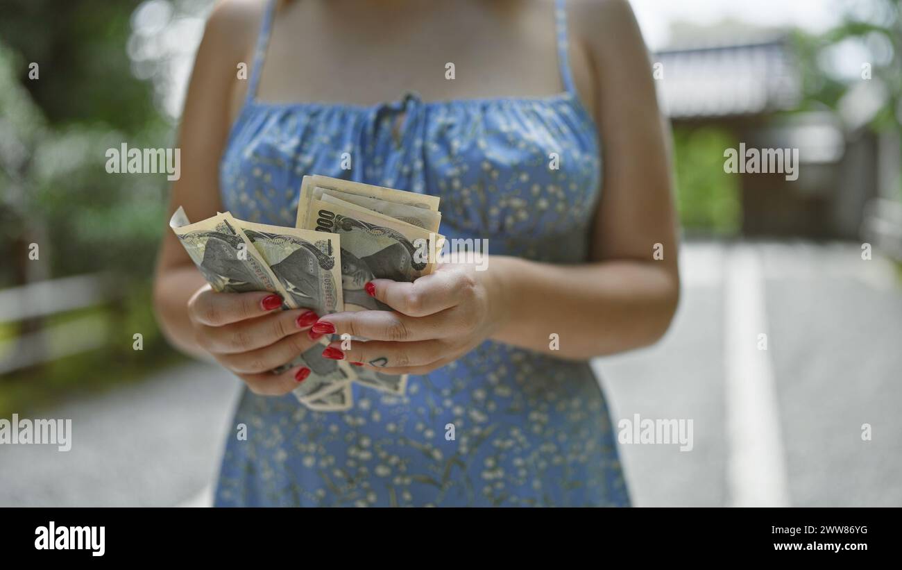 Young woman's hands, busy counting yen banknotes in the traditional ...