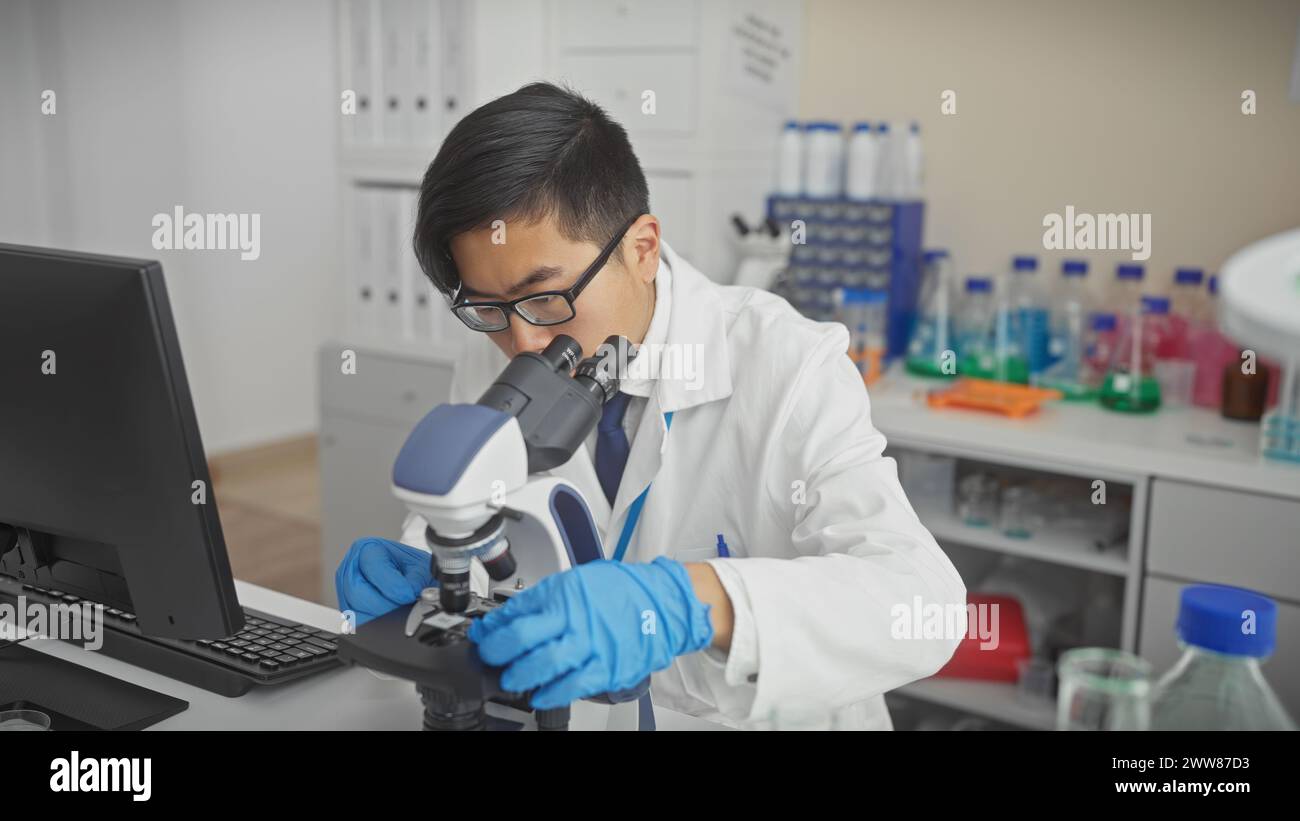 Focused asian man using microscope hi-res stock photography and images ...