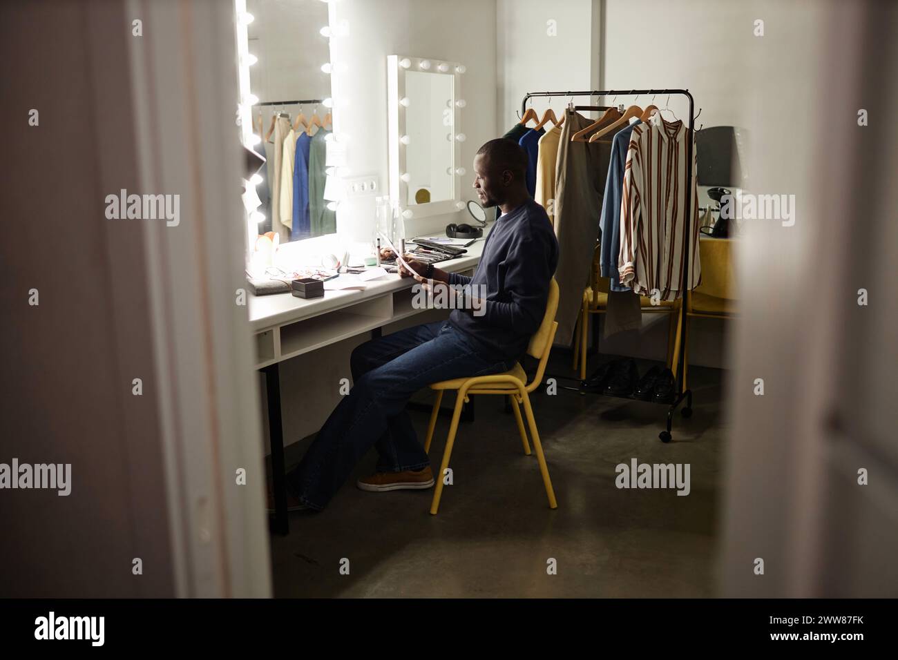 Wide angle shot of Black adult man reading script and rehearsing lines ...