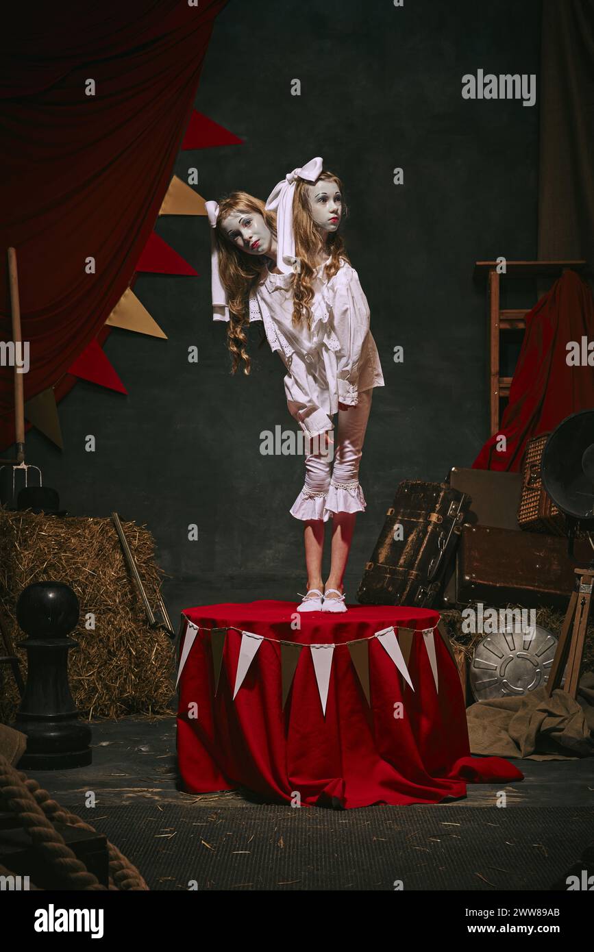 Siamese twin girls in white vintage costumes with makeup standing over ...