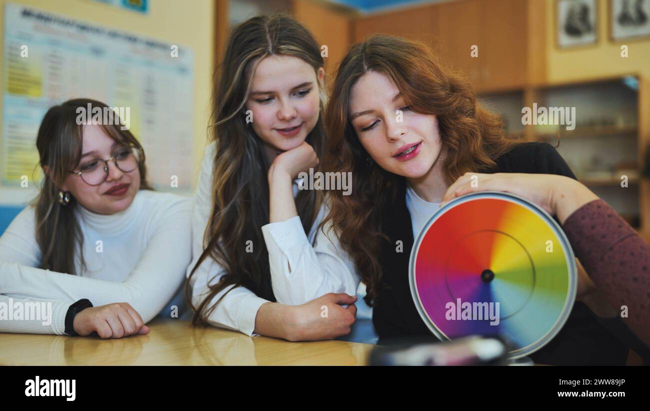 Students in physics class spin Newton's colorful wheel Stock Photo - Alamy