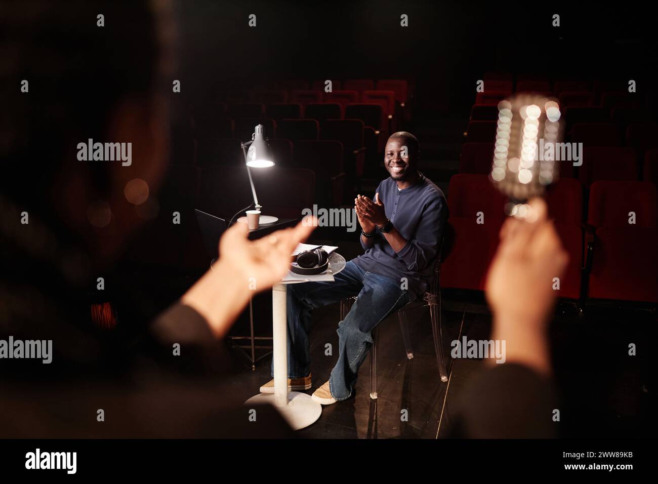 Portrait of smiling theater director applauding to unrecognizable ...