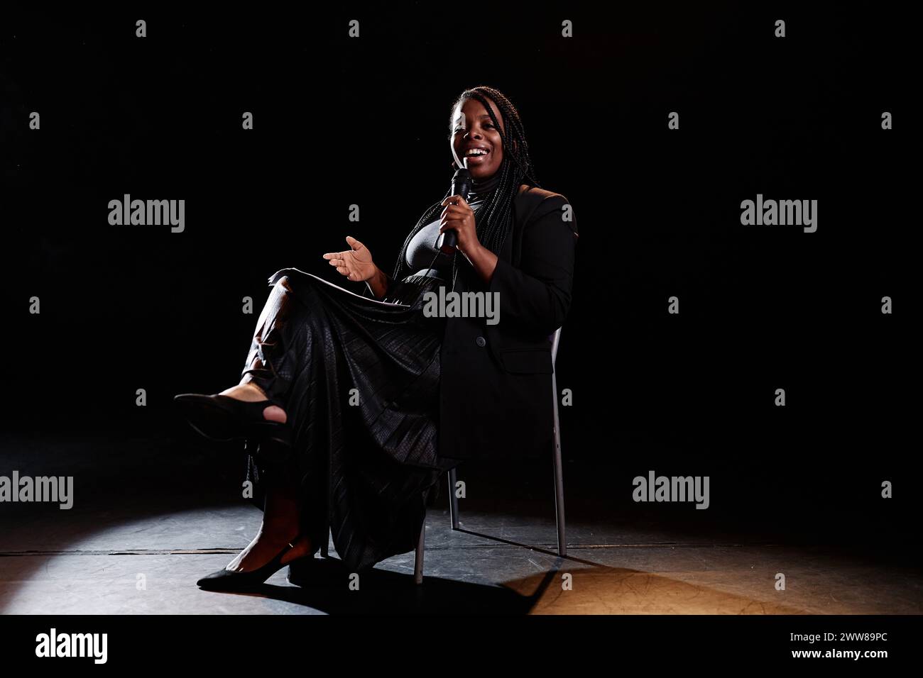 Minimal full length portrait of smiling Black woman performing comedy ...