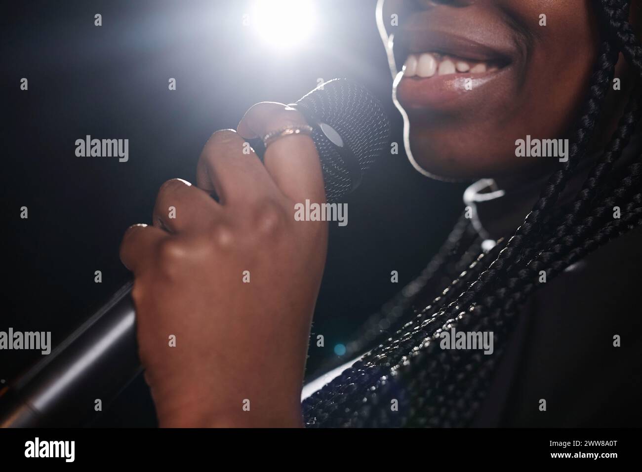 Close up of smiling Black woman holding microphone on stage with ...