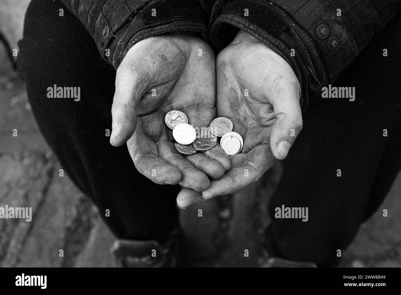 Poor homeless man holding coins outdoors, top view. Black and white ...