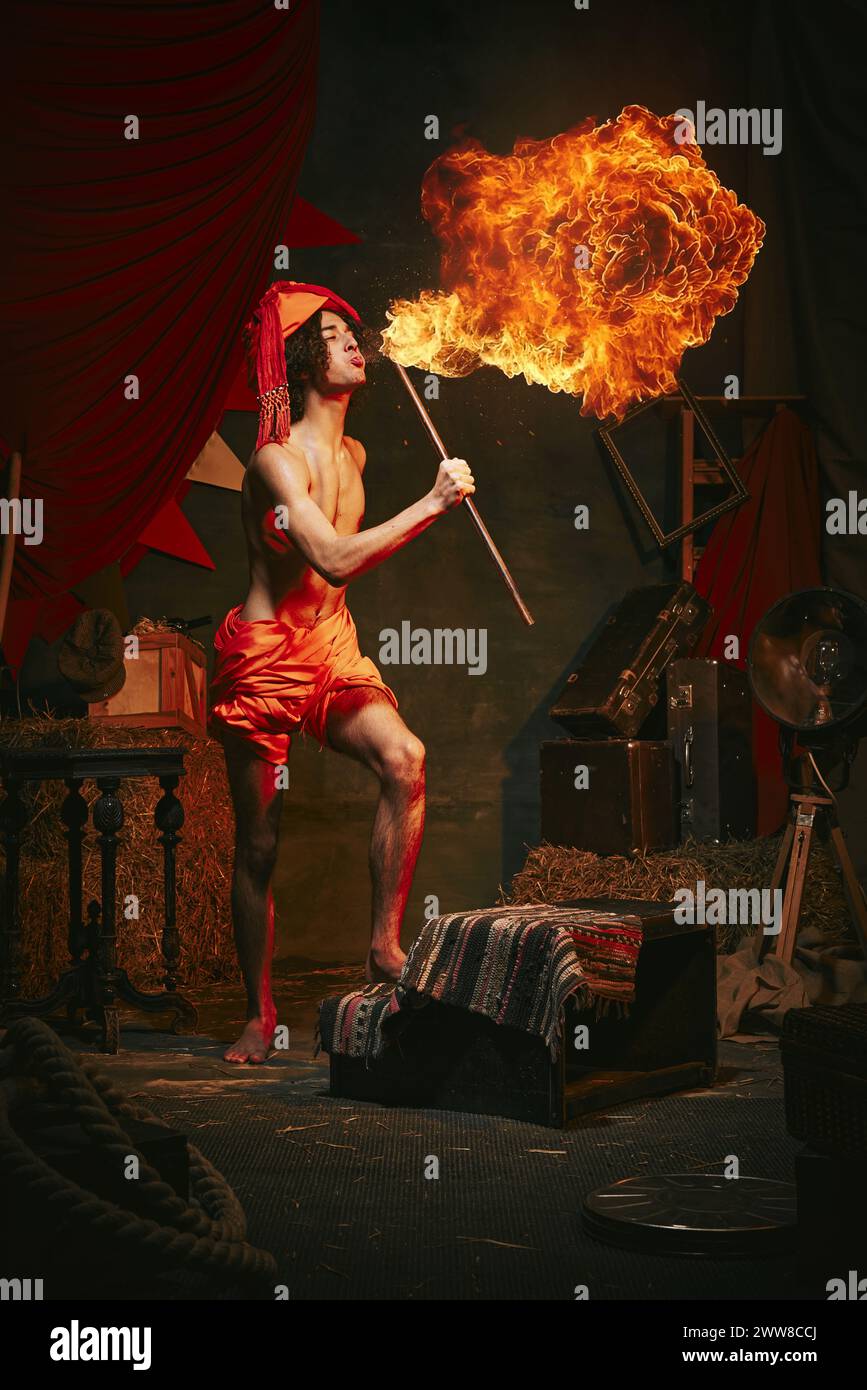 Fire show. Young man in turban breathes fire, displaying dramatic flame ...