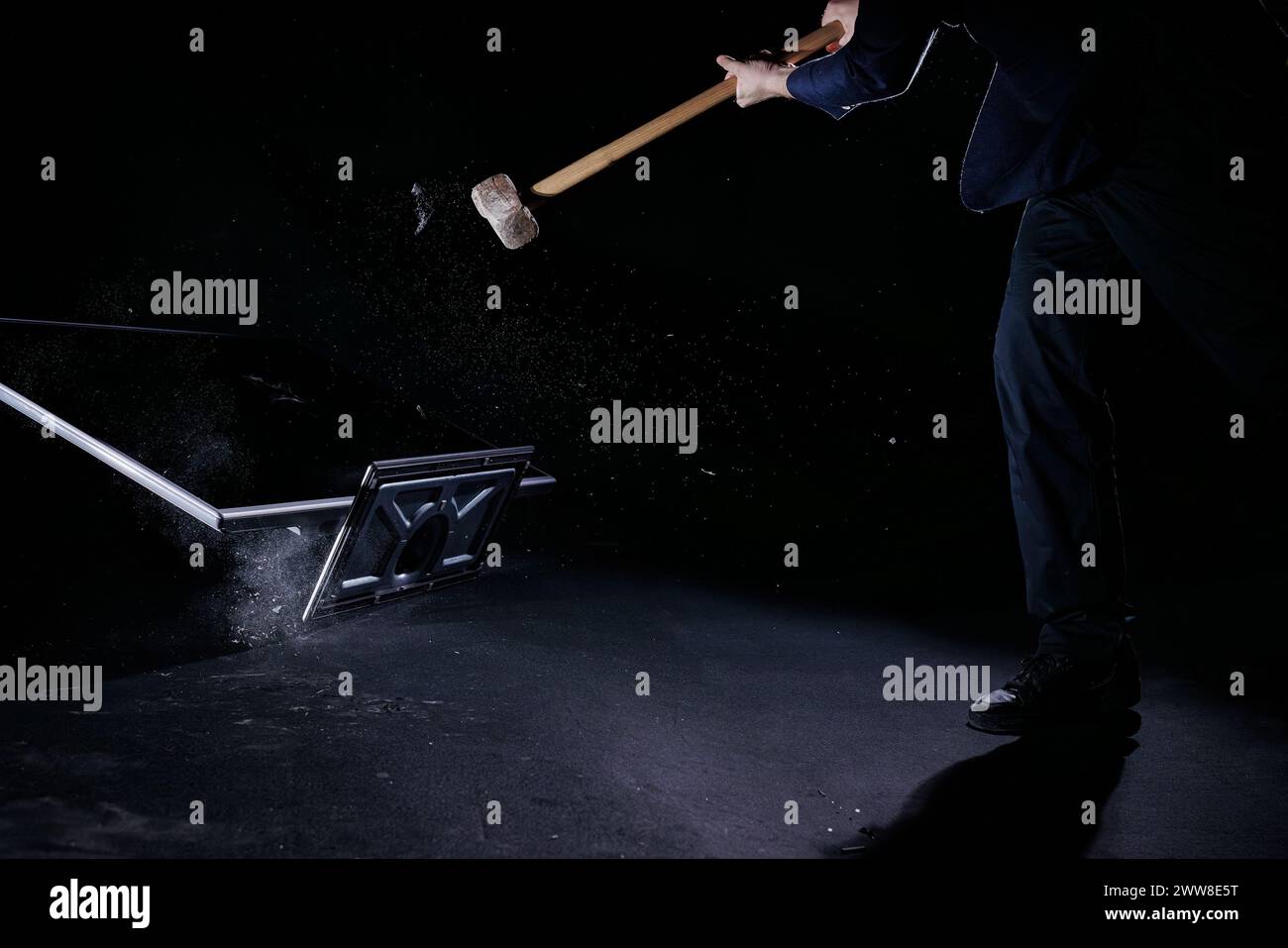 Man holding a sledgehammer, hitting and smashing a plasma television ...