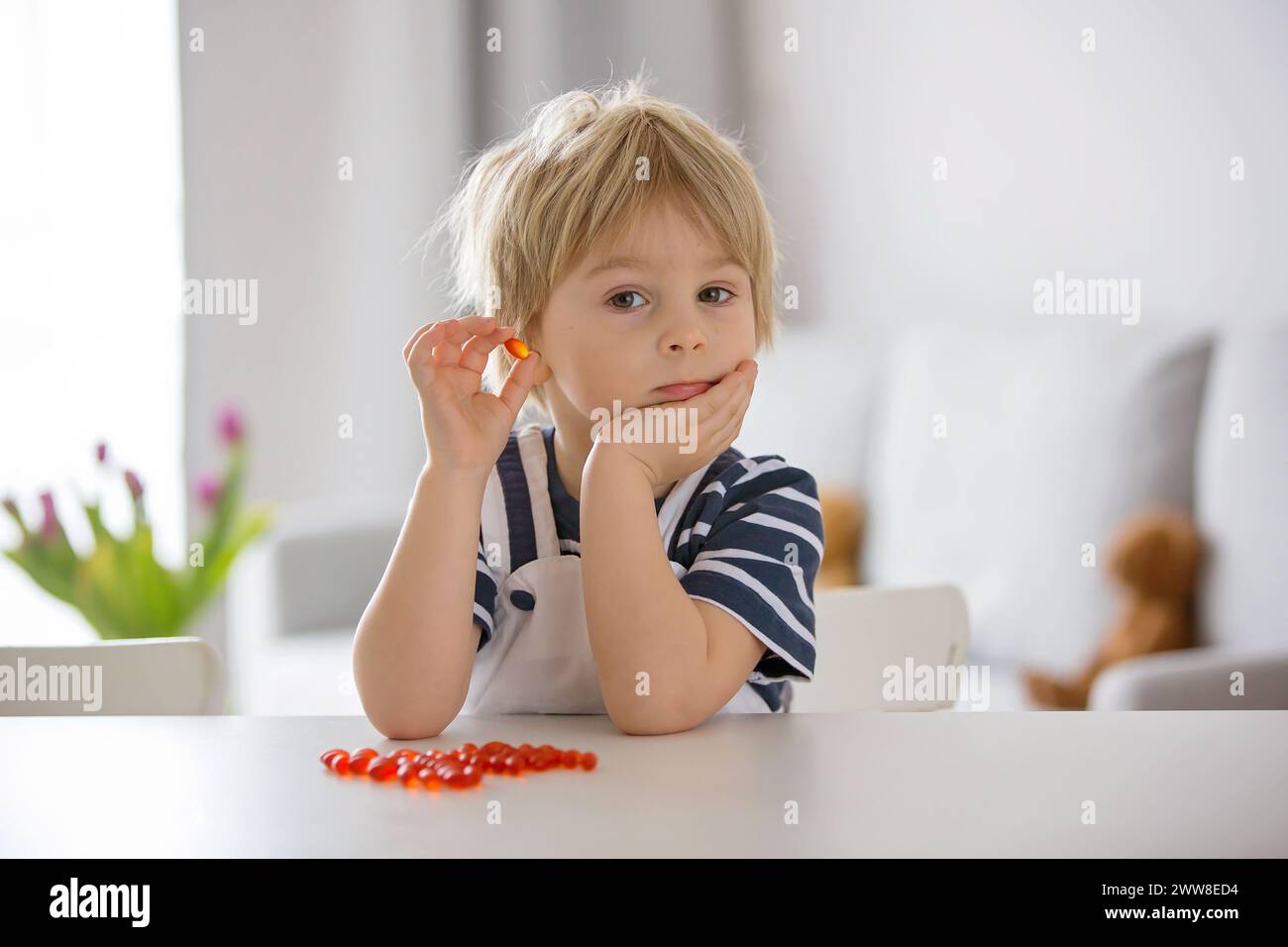 Cute little child, toddler boy, eating alfa omega 3 child supplement ...