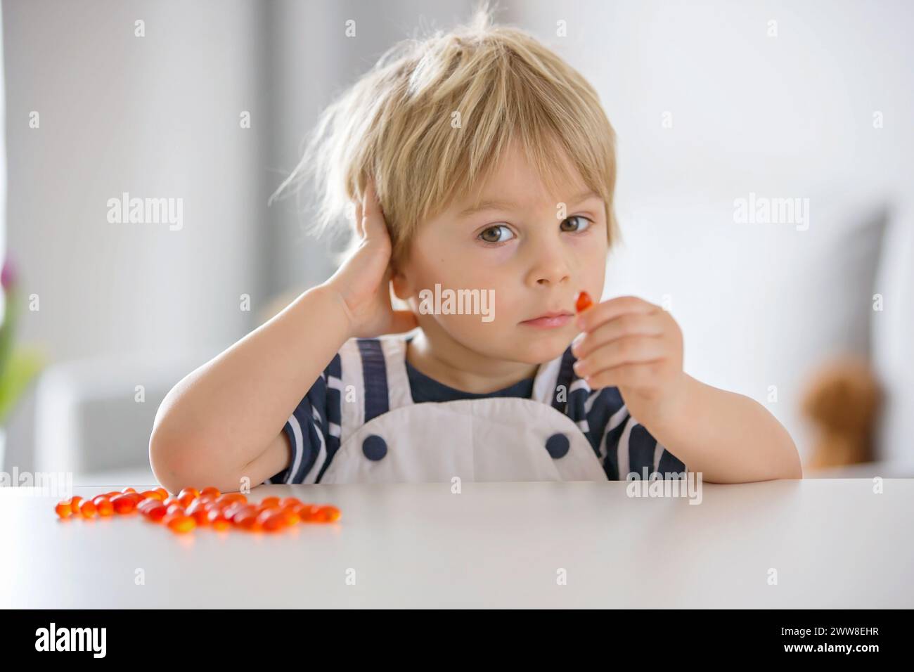 Cute little child, toddler boy, eating alfa omega 3 child supplement ...