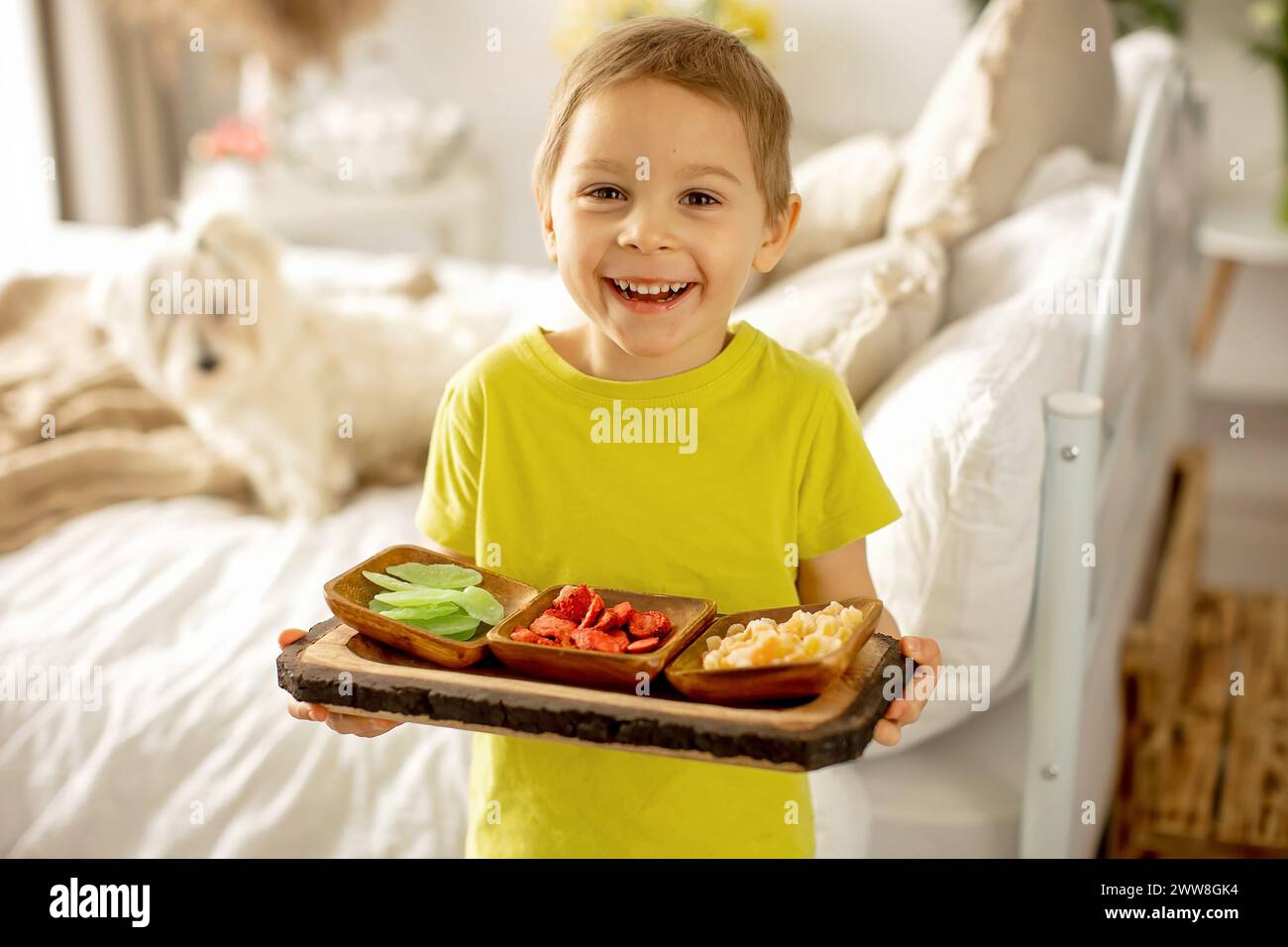 Cute little preschool child, boy, eating dried fruits at home ...