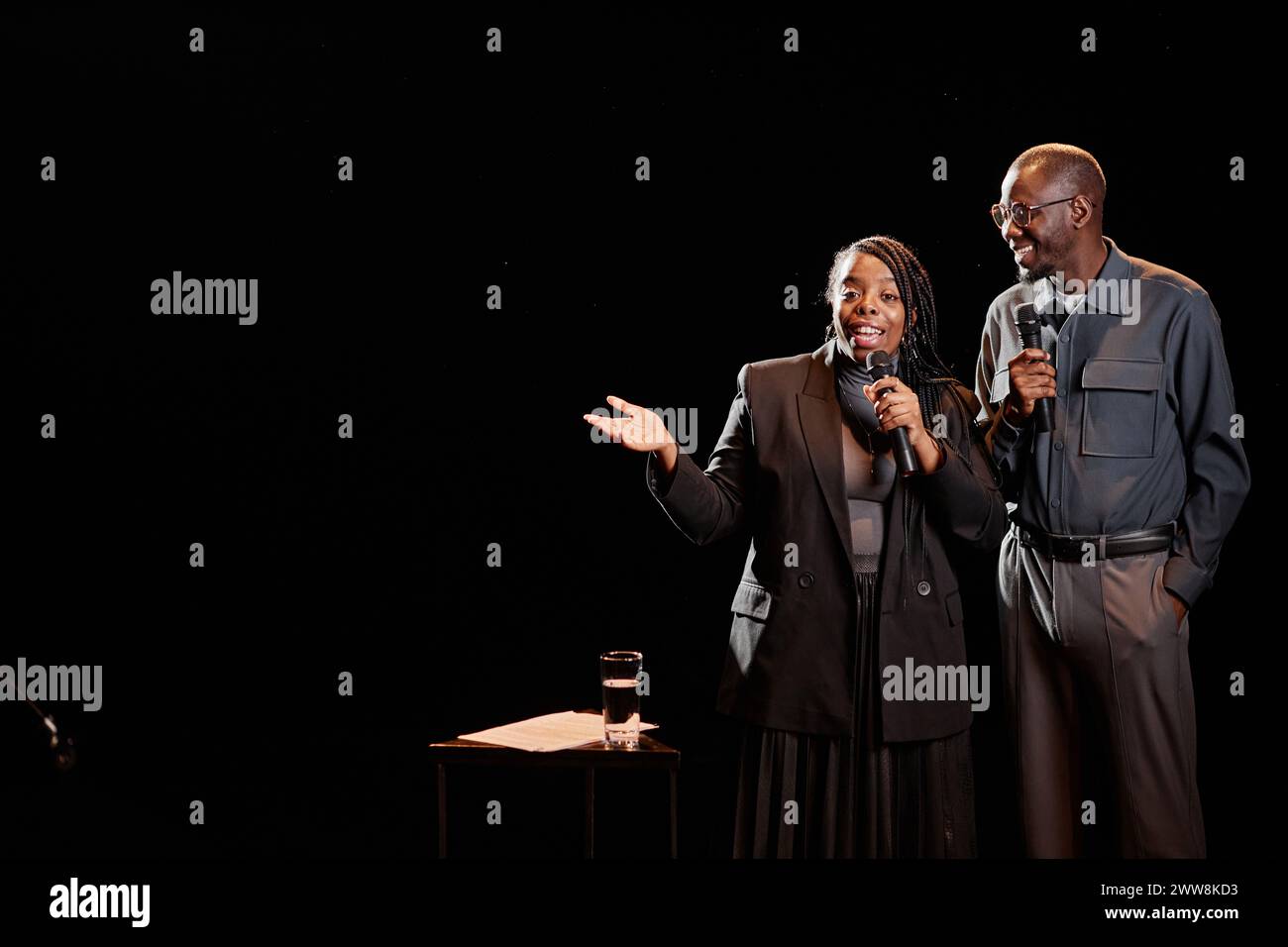 Portrait of two African American performers on dark stage with ...