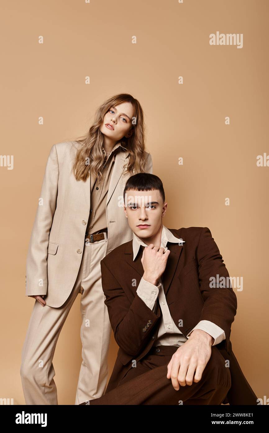 appealing couple in sophisticated suits posing together and looking at ...