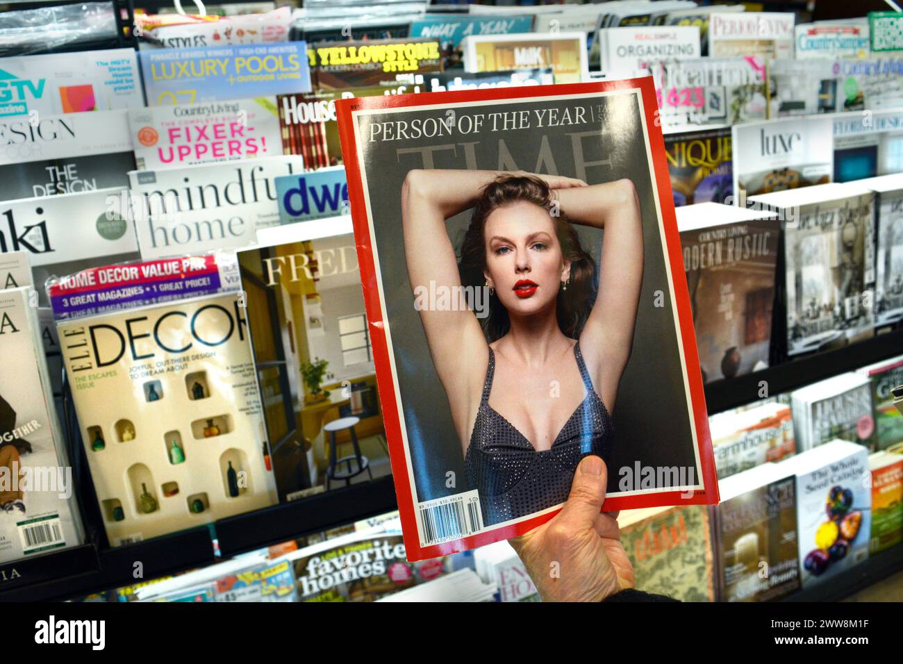 A bookstore customer holds a copy of Time magazine with a cover photograph of singer Taylor ...