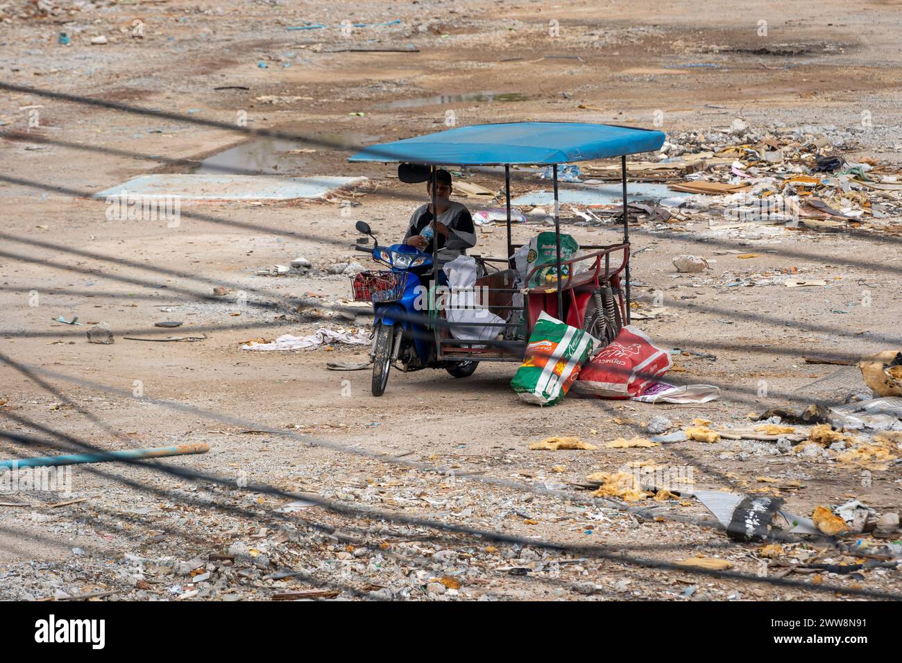 A woman waste picker is seen sitting on her saleng (Thai three-wheel ...