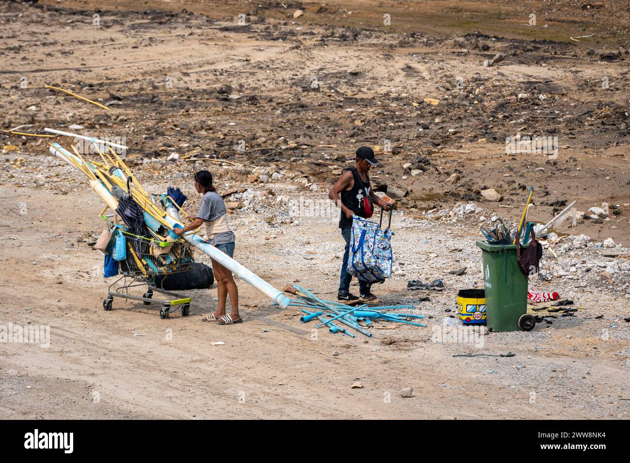 Waste pickers are seen collecting plastic pipes, on cleared land after ...