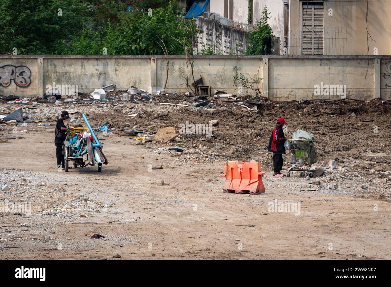 Two male waste pickers are seen searching for garbage, on a cleared ...