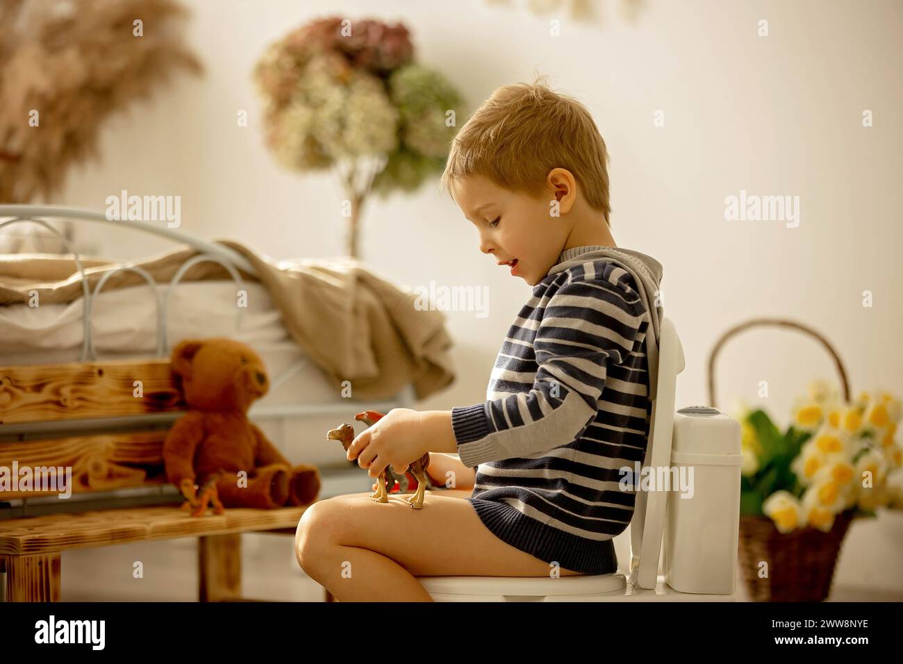 Cute toddler child, boy, using potty at home, while playing with toys ...