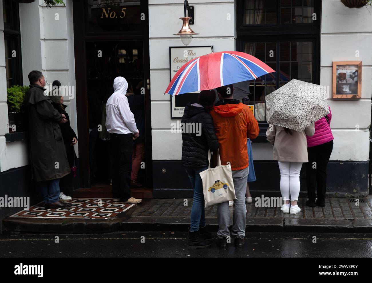 People watch the coronation of King Charles III on screen at a pub in ...