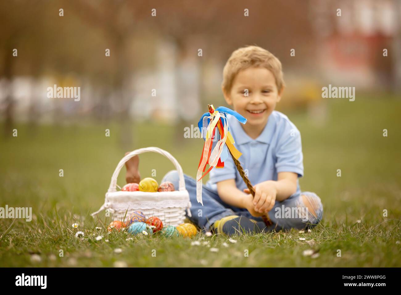 Cute preschool child, whipping his sister on Easter with twig, braided ...