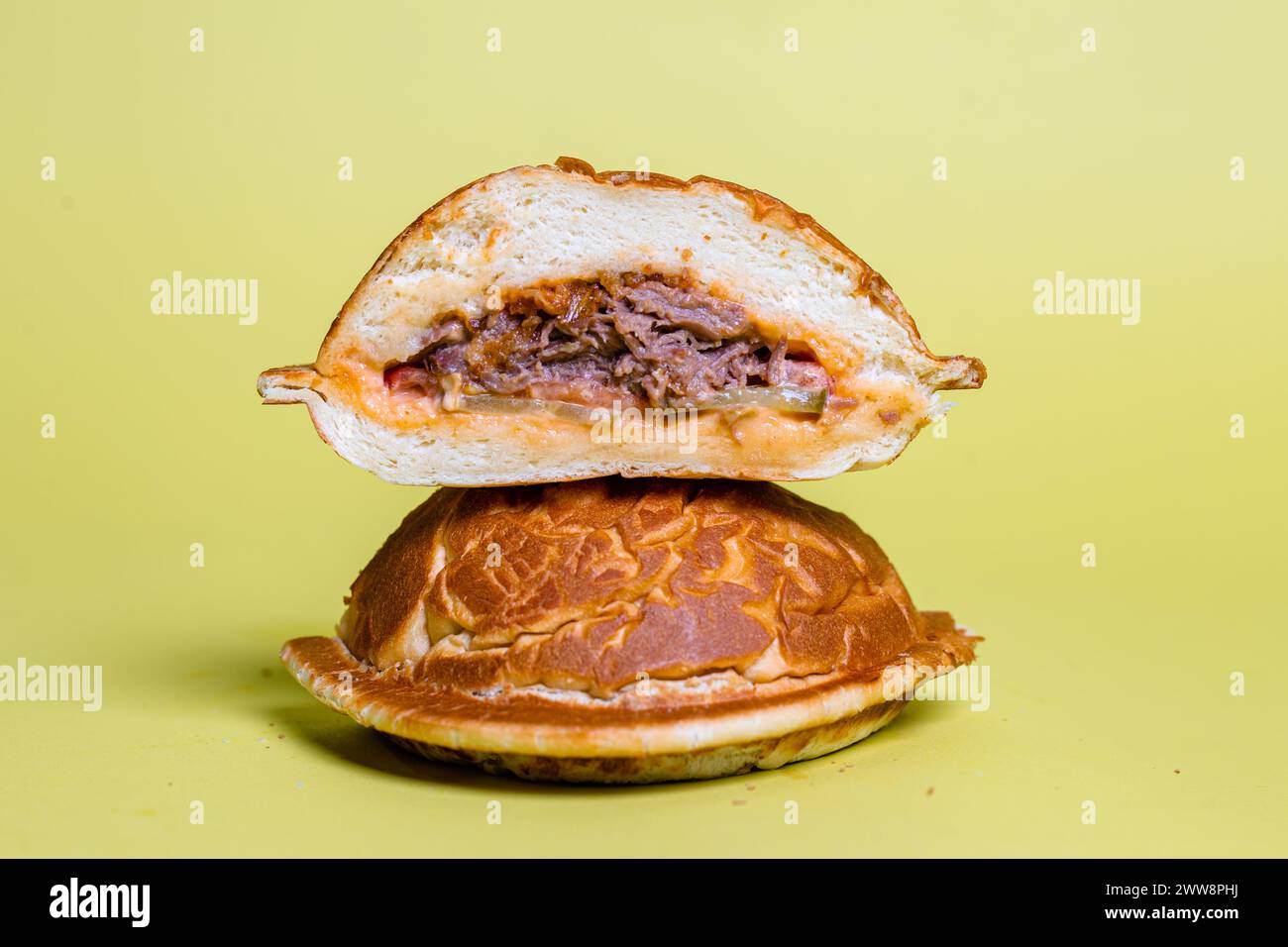 juicy burger cut with delicious filling on a yellow background Stock ...
