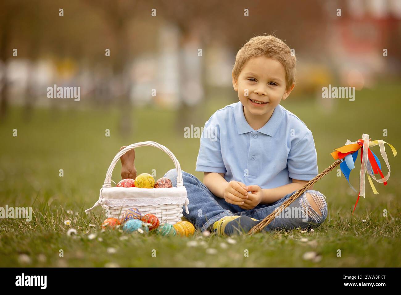 Cute preschool child, whipping his sister on Easter with twig, braided ...