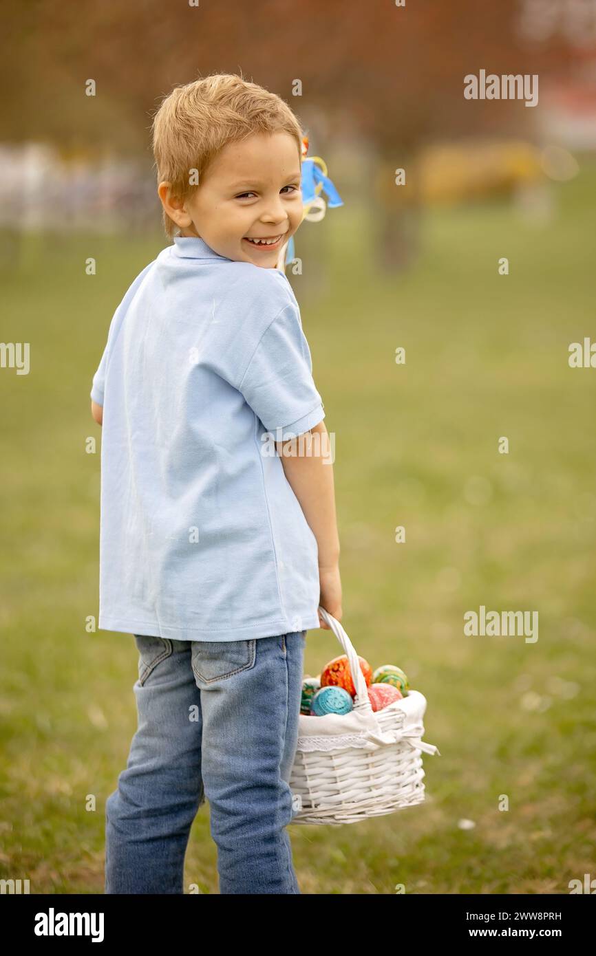 Cute preschool child, whipping his sister on Easter with twig, braided ...