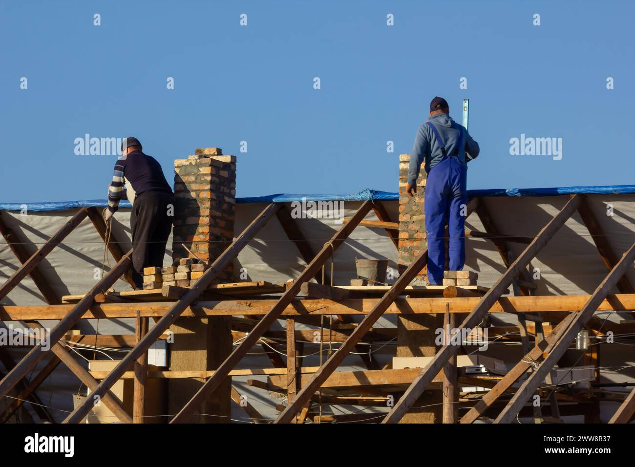 Villagers working together to build a house rooftop Stock Photo - Alamy
