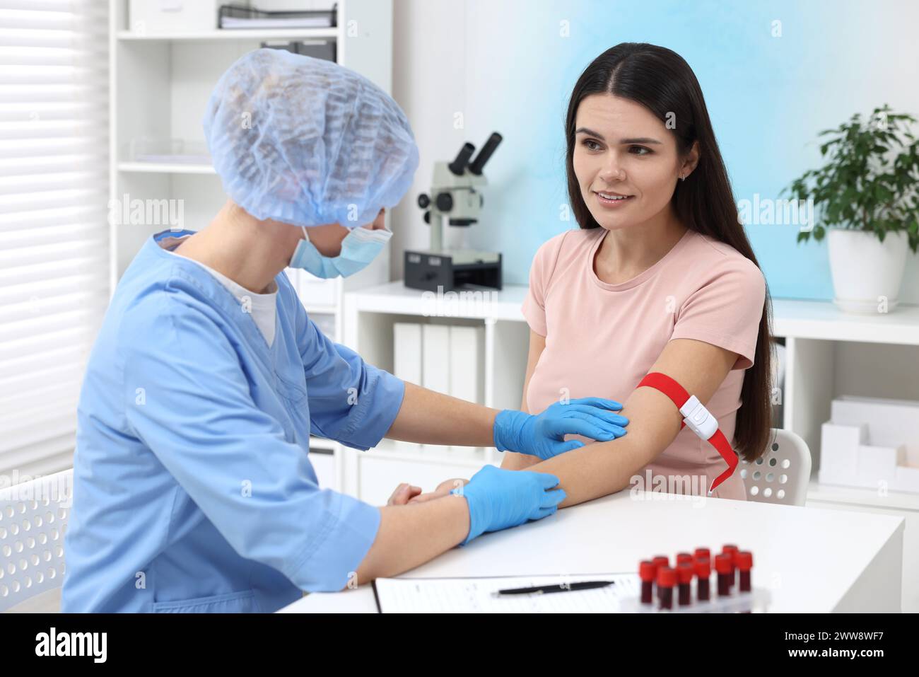 Laboratory testing. Doctor taking blood sample from patient at white ...