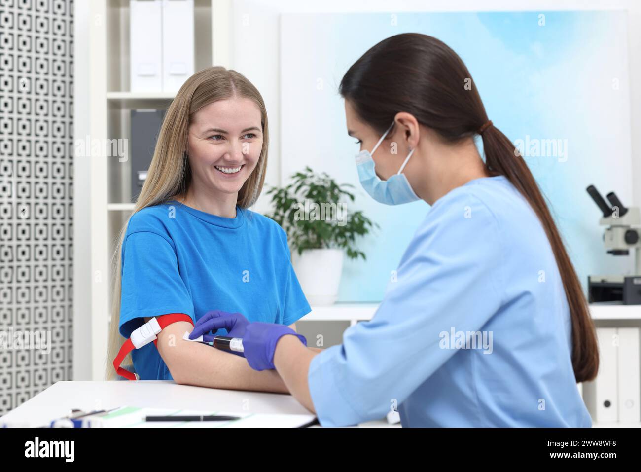 Laboratory testing. Doctor taking blood sample from patient at white ...