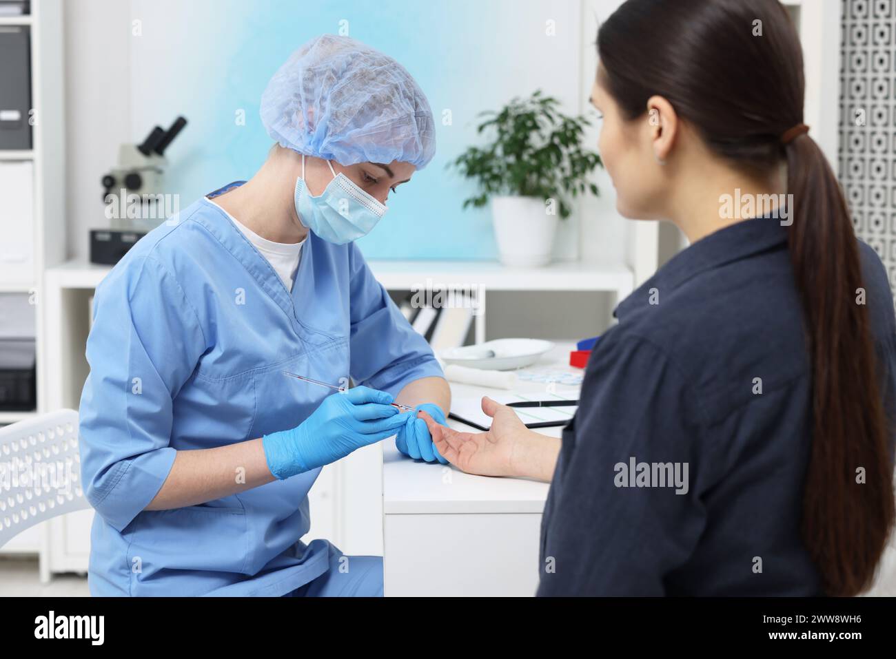 Laboratory testing. Doctor taking blood sample from patient at white ...
