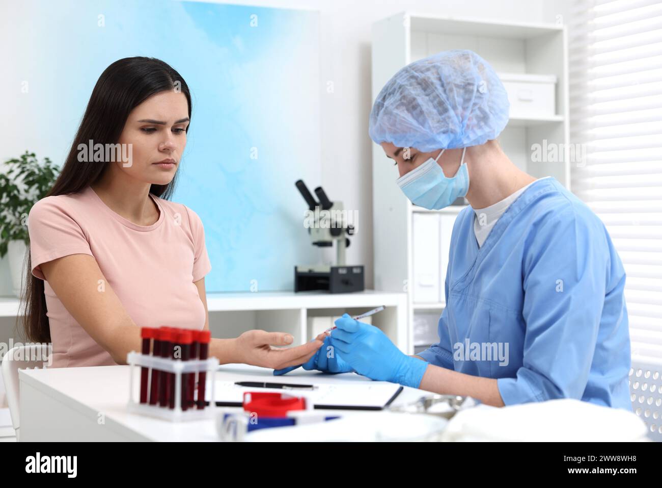 Laboratory testing. Doctor taking blood sample from patient at white ...