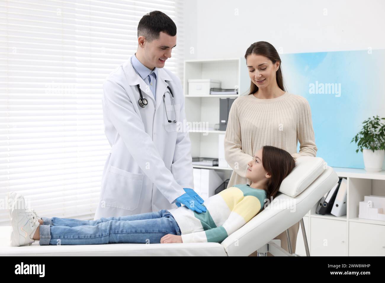 Doctor examining stomach girl hi-res stock photography and images - Alamy