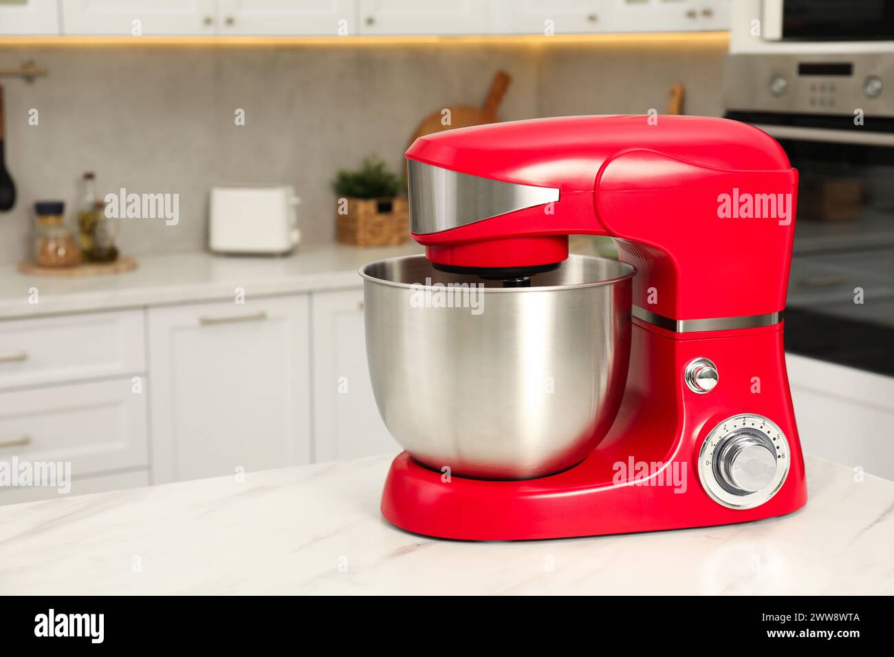 Modern red stand mixer on white marble table in kitchen, space for text ...