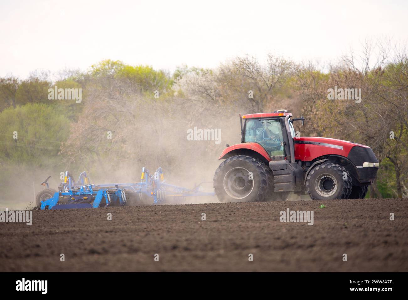 Green tractor cultivates field hi-res stock photography and images - Alamy
