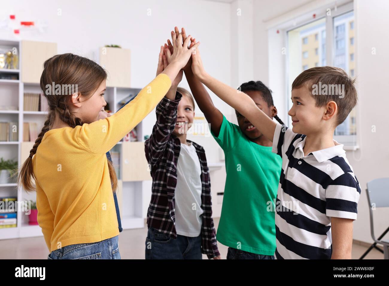 Happy children giving high five at school Stock Photo - Alamy