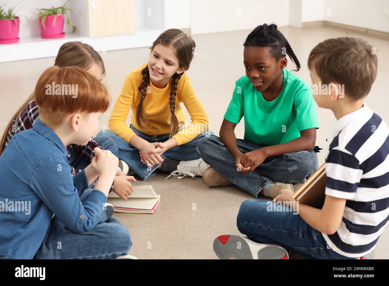 Cute children discussing in classroom at school Stock Photo - Alamy
