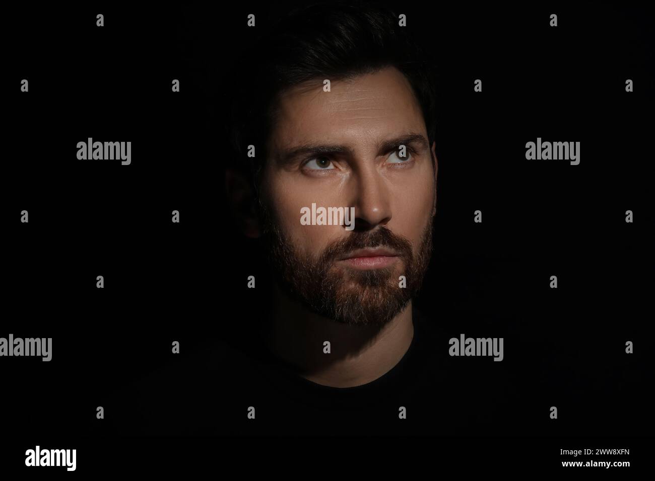 Evil eye. Man with scary eyes in darkness Stock Photo - Alamy