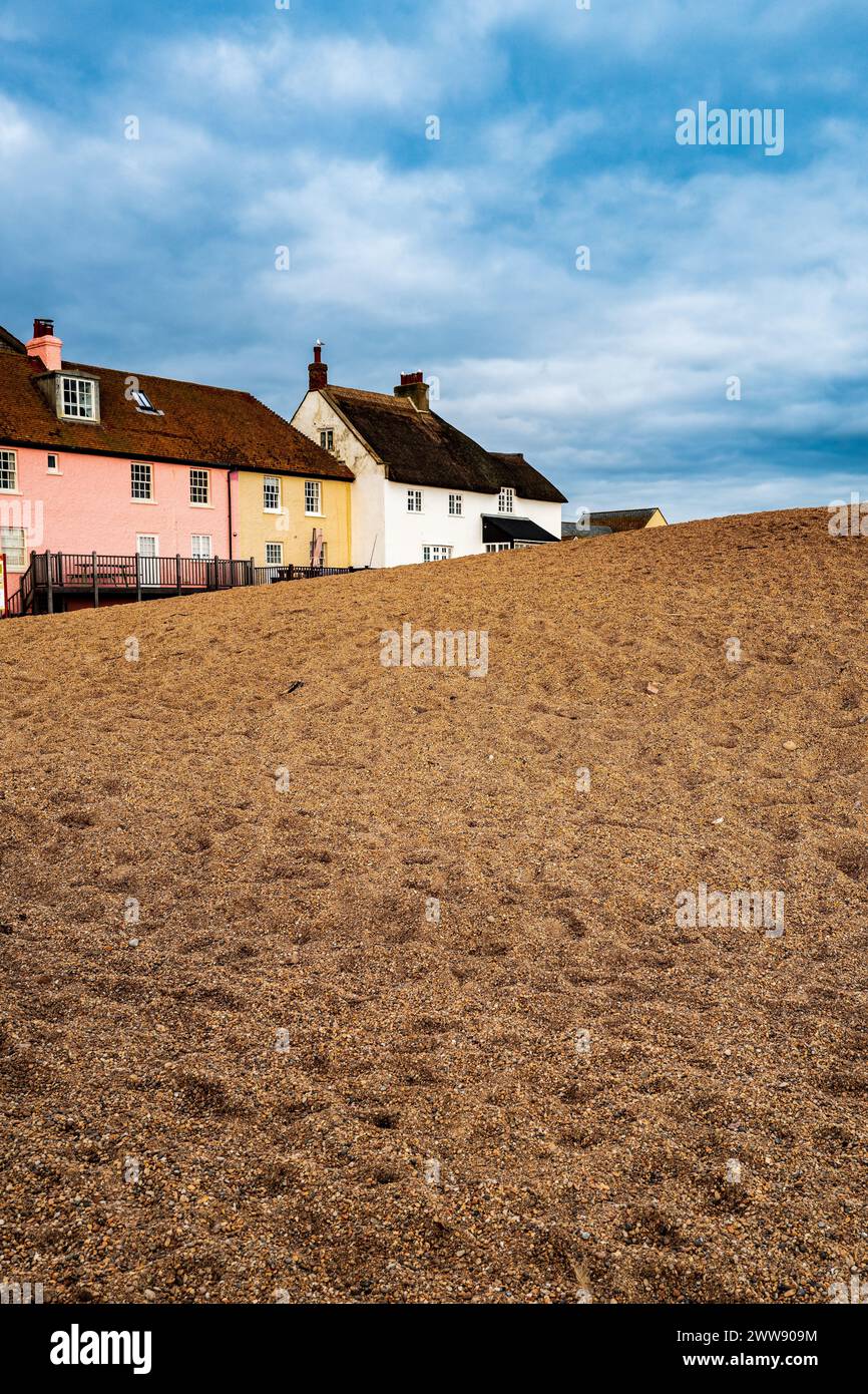Pink, yellow and white coastal cottages, blue sky, light clouds ...