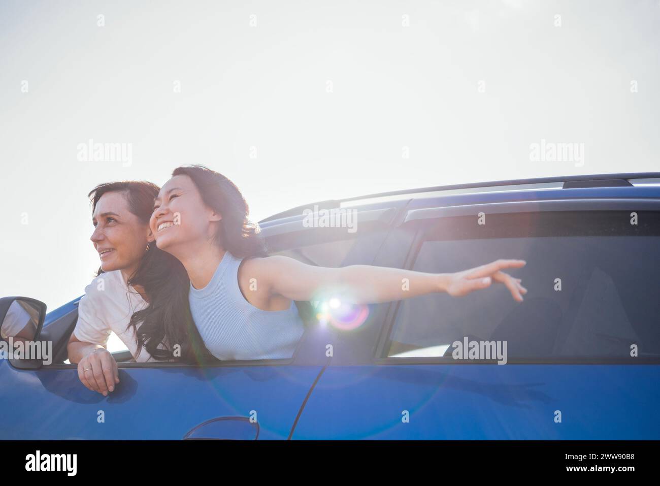 Young women look out of the car window and laugh. Smiling girls of ...