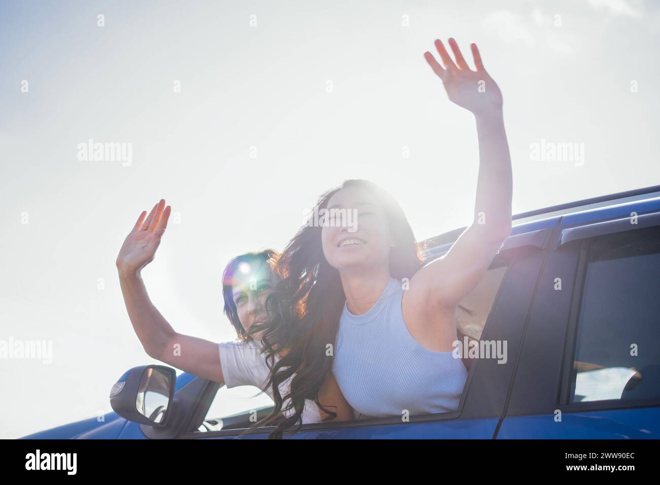 Young women look out of the car window and laugh. Smiling girls of ...