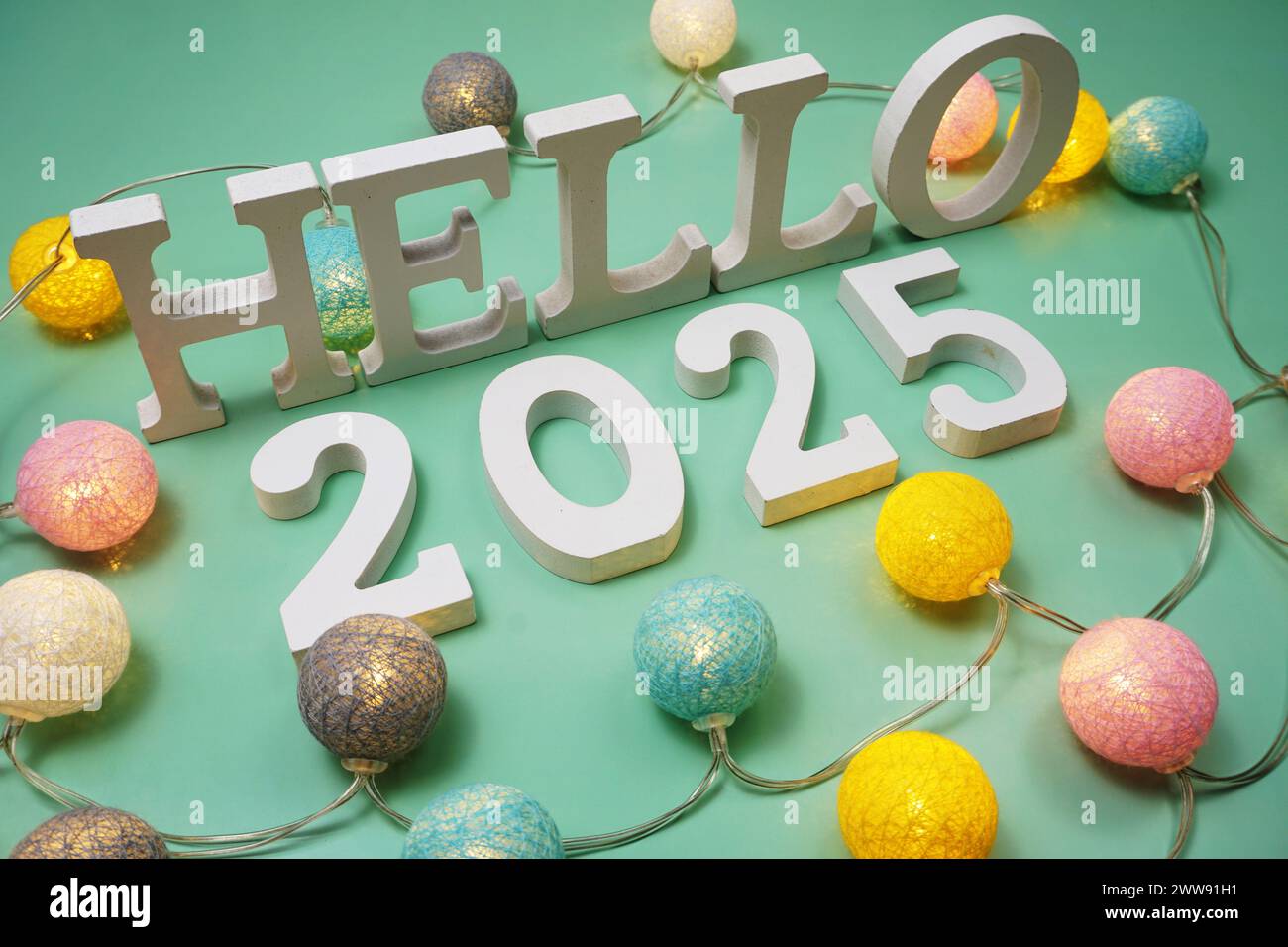 Hello 2025 alphabet letter with LED cotton balls on green background ...