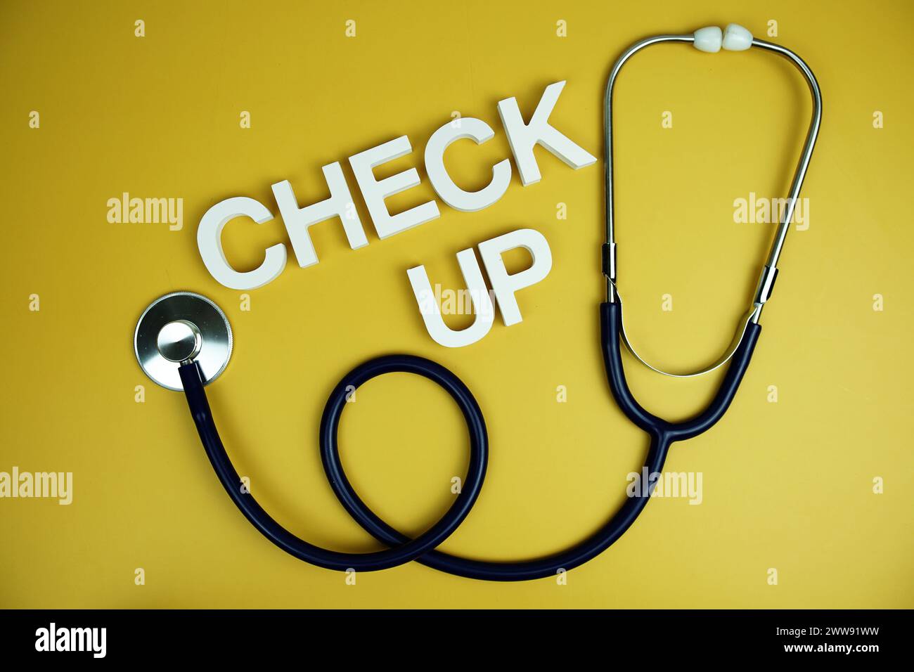 Stethoscope and Check up alphabet letters top view on yellow background ...