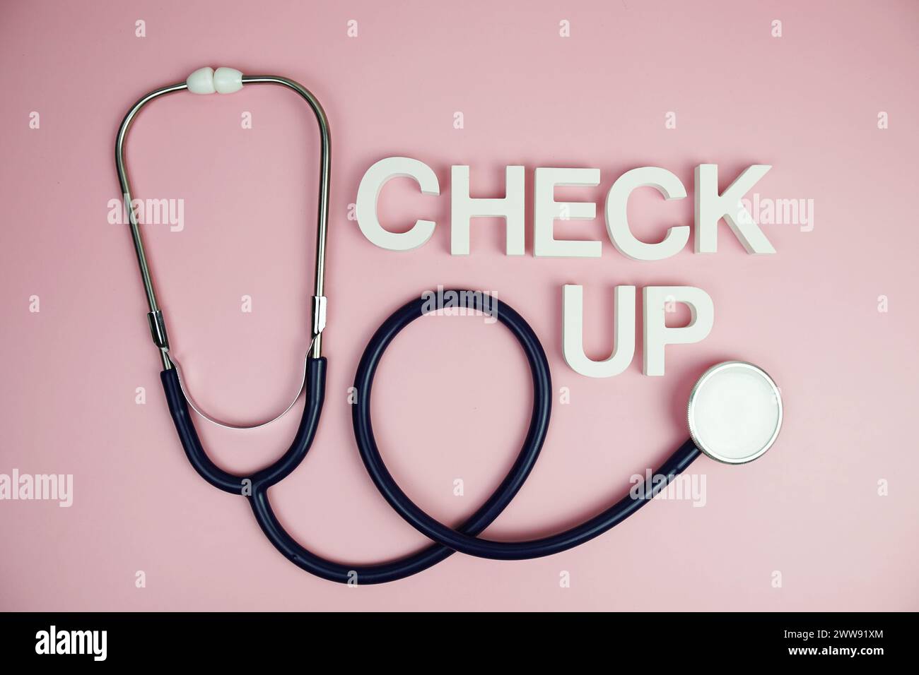Stethoscope and Check up alphabet letters top view on pink background ...