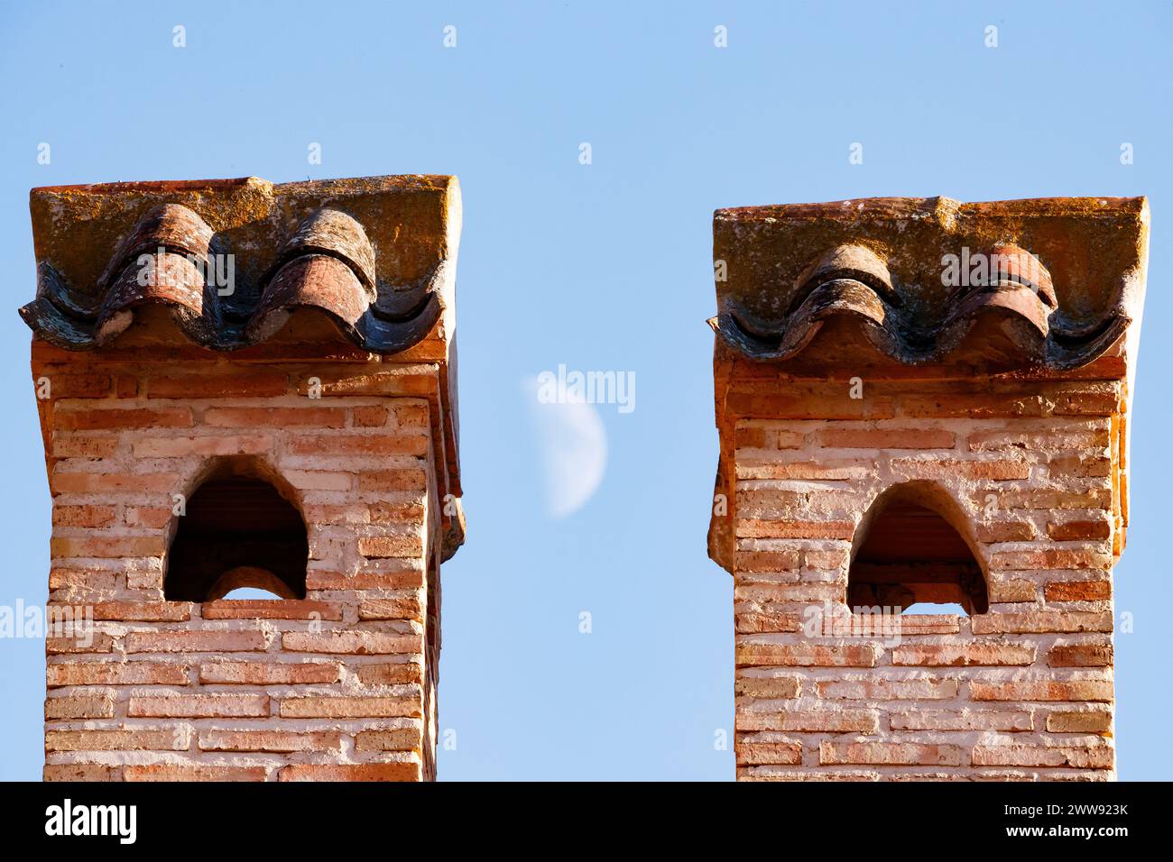 Two chimneys with the moon in San Carlos del valle Stock Photo - Alamy