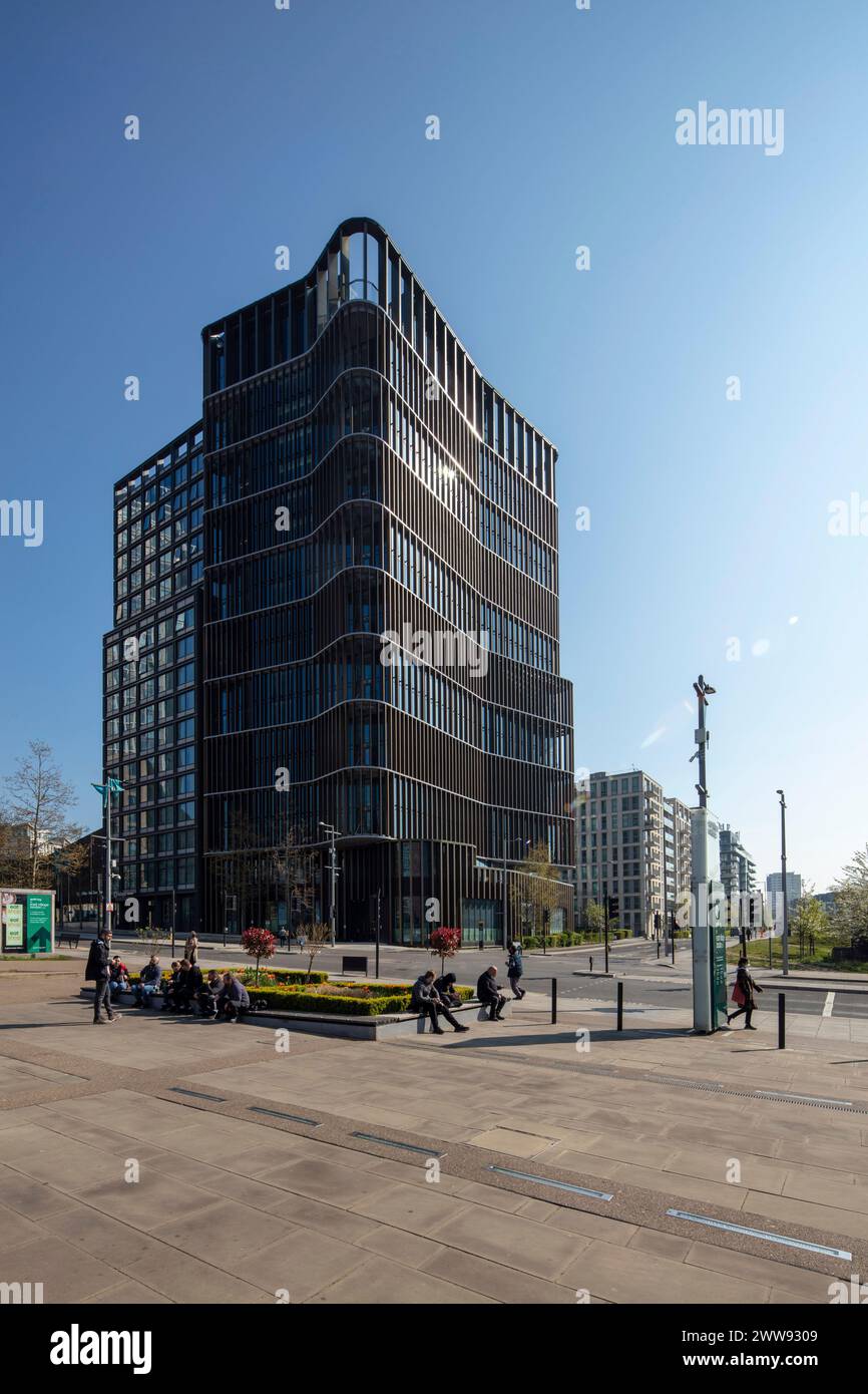 People sitting in front of the building drinking coffee and eating. The ...