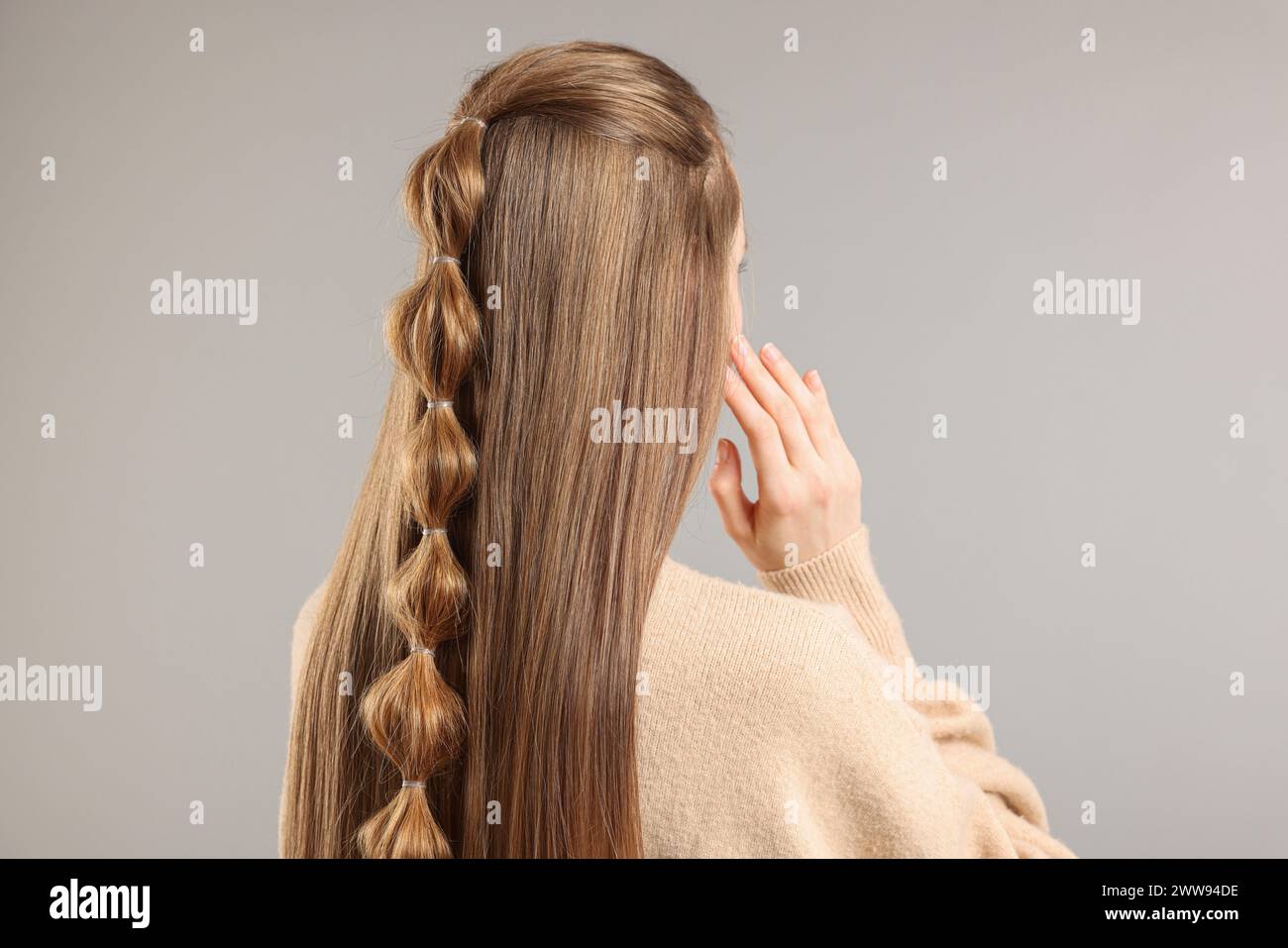 Woman with braided hair on grey background, back view Stock Photo - Alamy