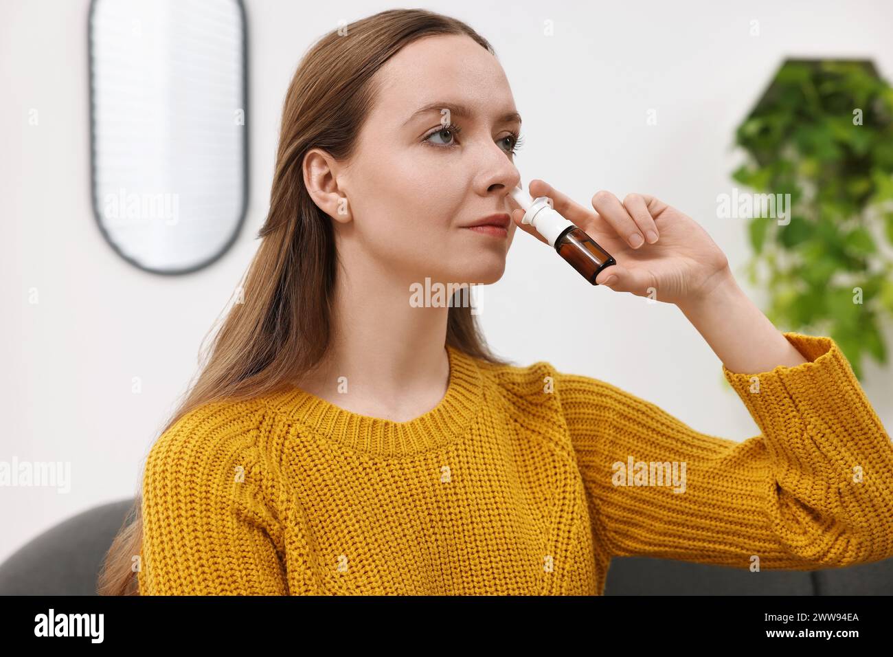 Medical drops. Young woman using nasal spray indoors Stock Photo - Alamy