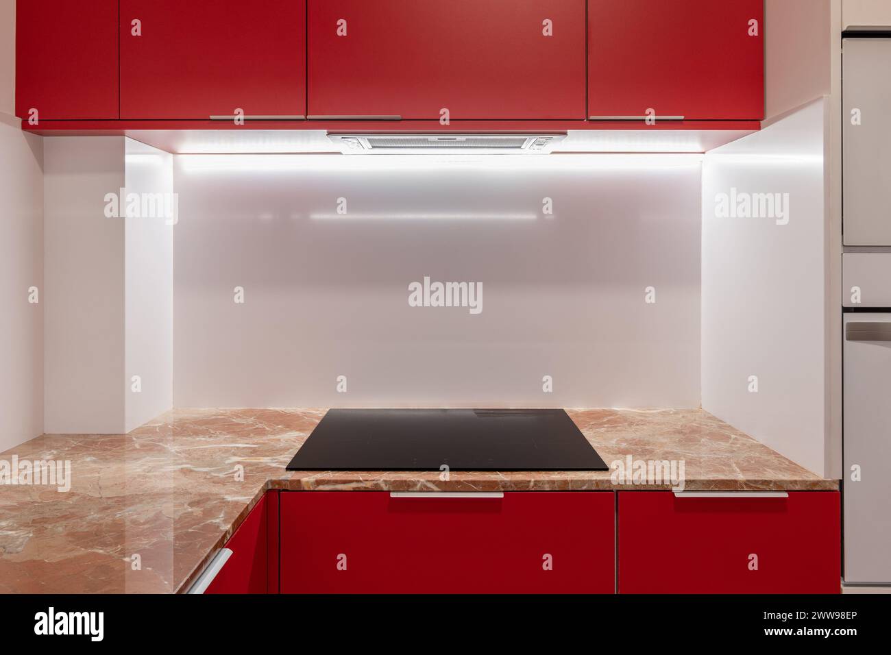 A modern Kitchen With Red Cabinets And A Black Stove Stock Photo - Alamy